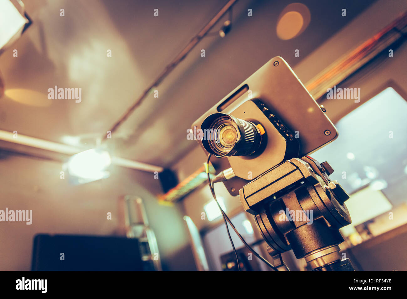Film camera on a tripod in a television broadcasting studio, spotlights ...