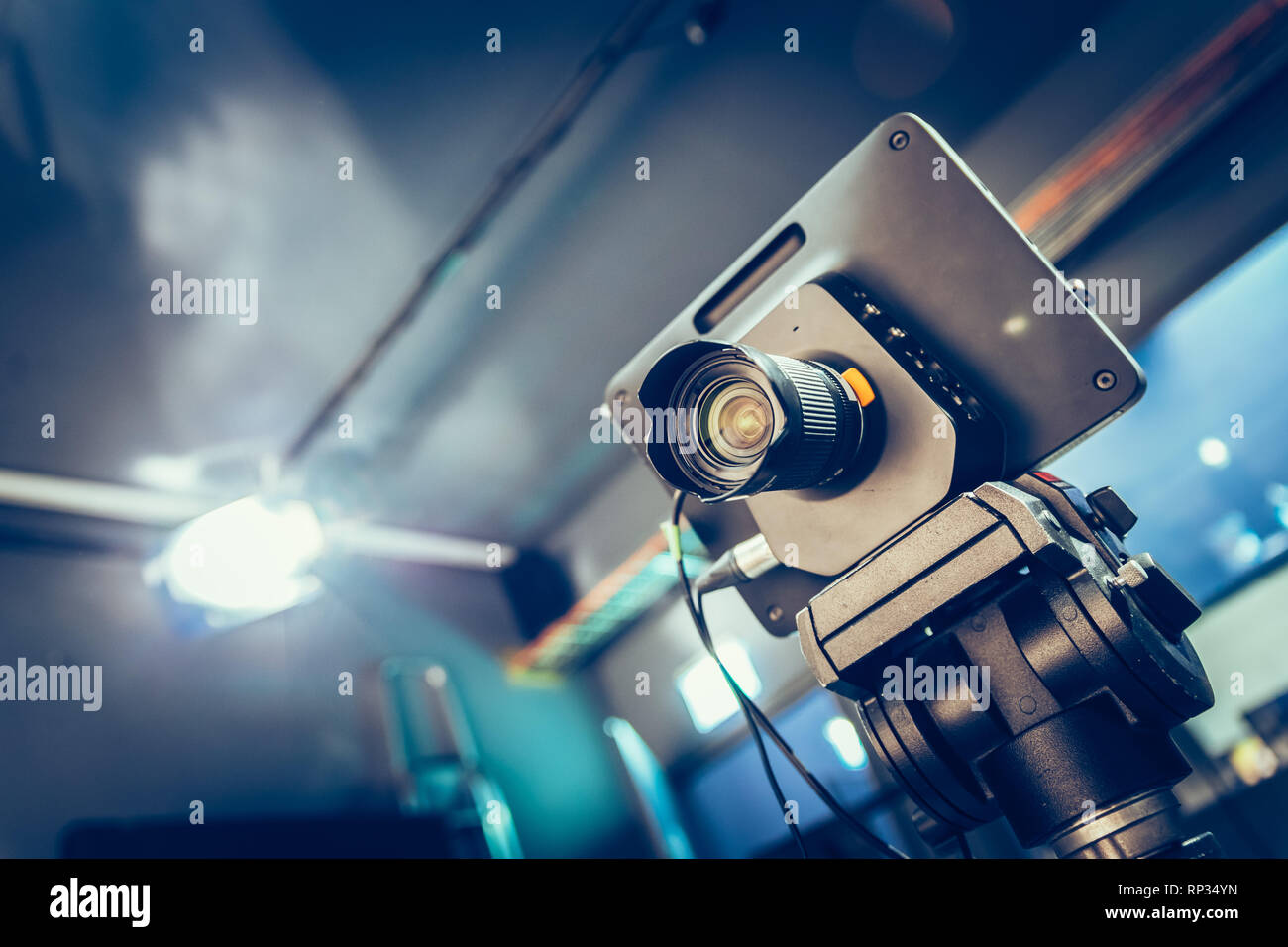 Film camera on a tripod in a television broadcasting studio, spotlights ...