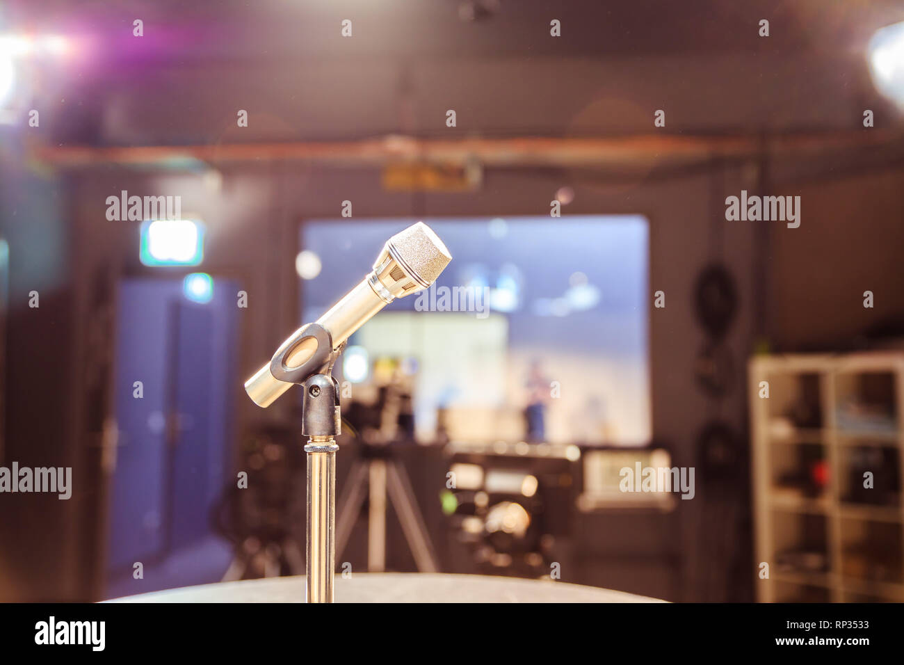Metal microphone in the studio, studio lights in the blurry background ...