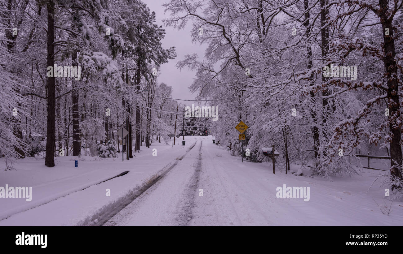 Snow covered street with tire tracks in residential neighborhood Stock ...