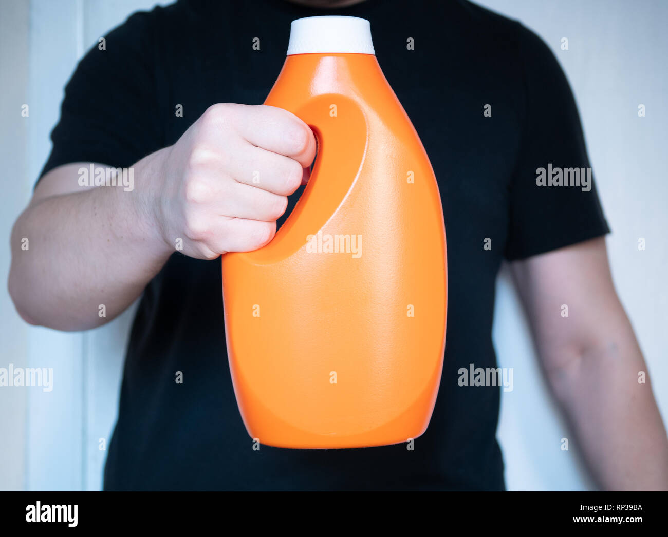 closeup orange color plastic bottle of detergent or washing machine gel ...