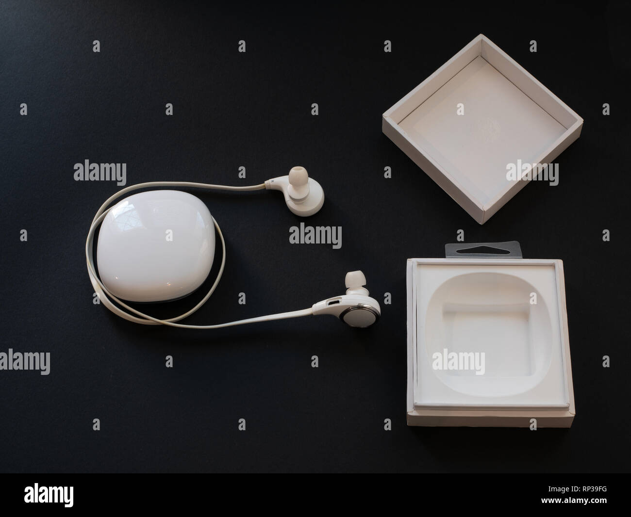 white opened box with wireless in-ear headphones headset on black ...