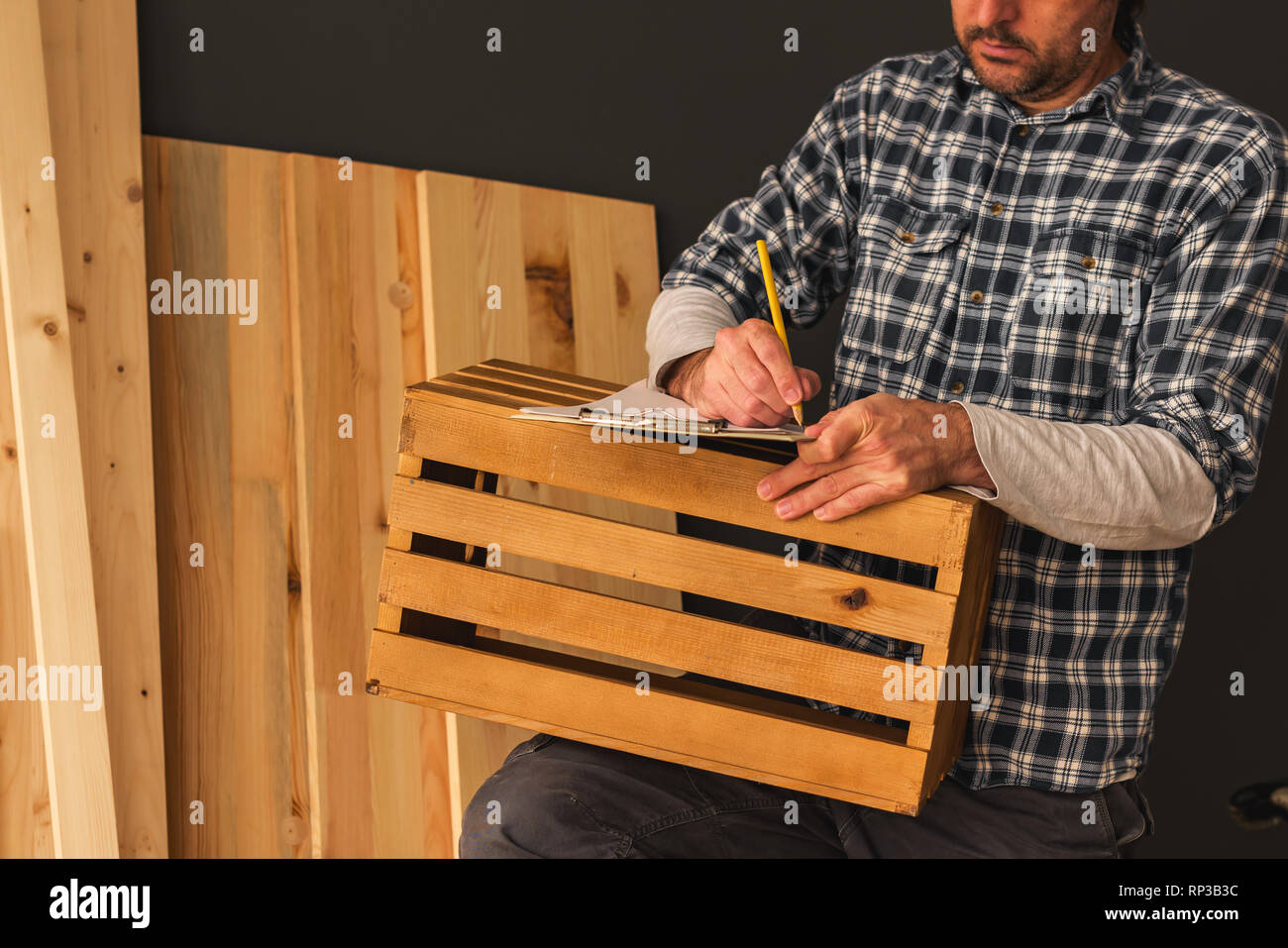 Carpenter making wooden crate in small business woodwork workshop ...
