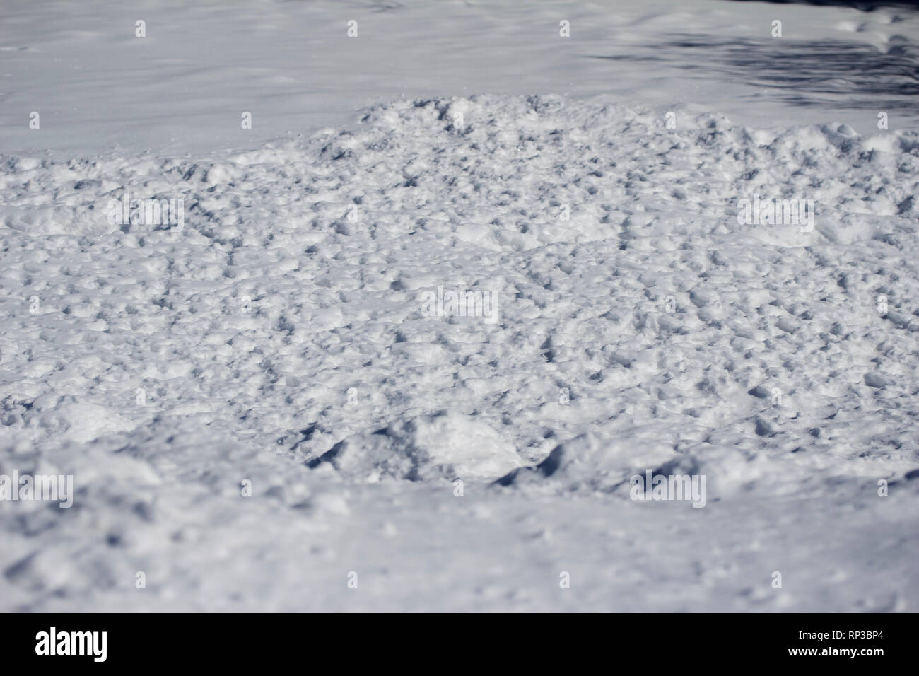 Close up abstract background view of white snow texture on a shoveled ...