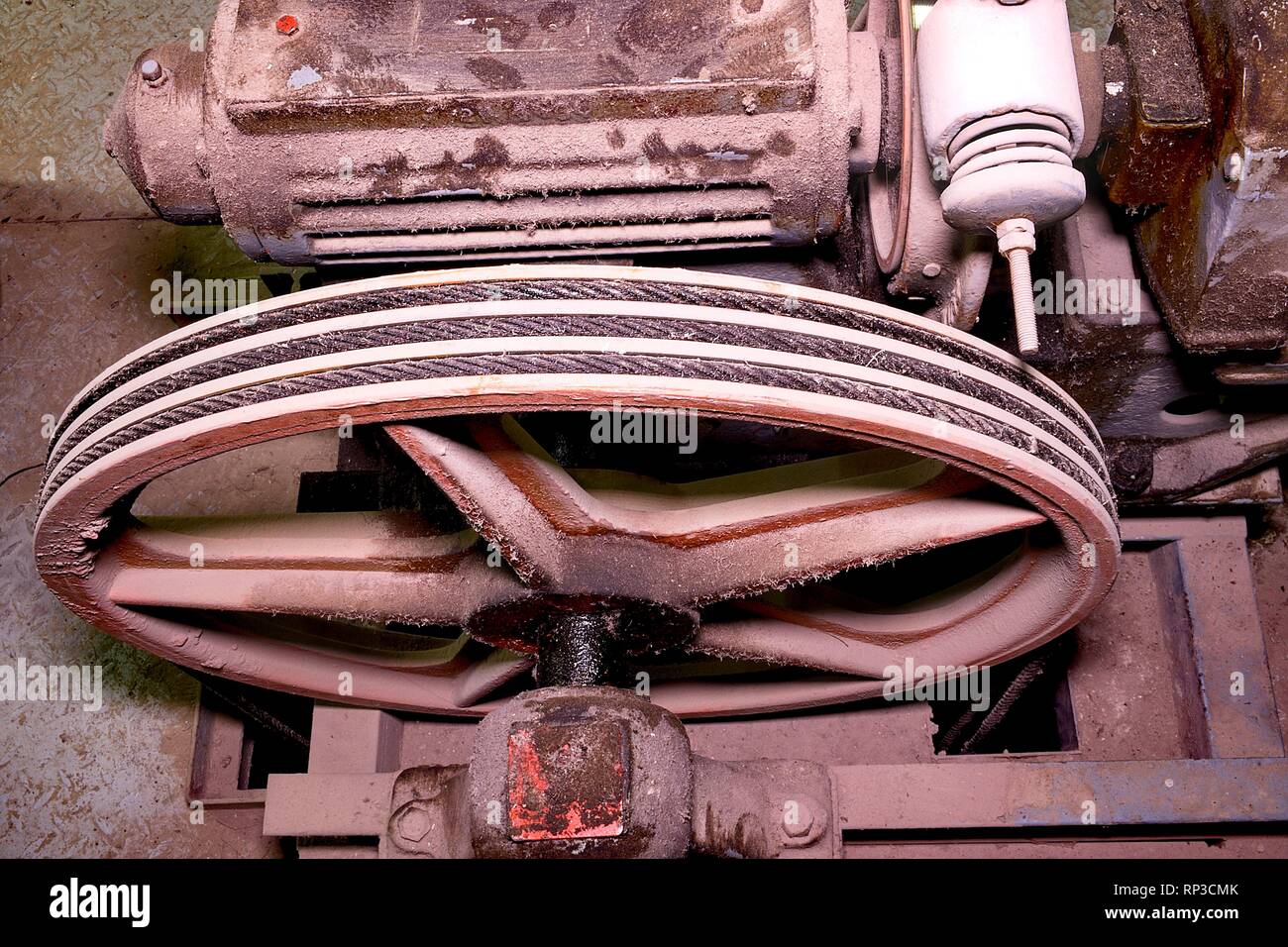 Old pulley wheel and engine in engine room. Closeup Stock Photo - Alamy