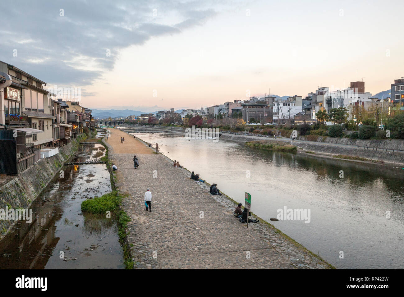 The Kamo River, in Kyoto, Japan, in winter. The riverbanks are popular ...