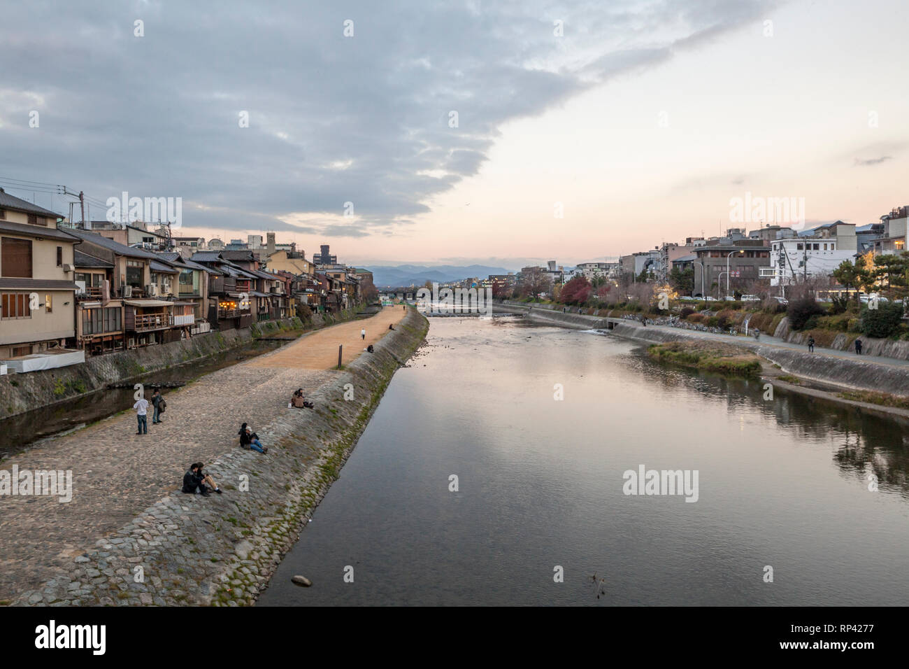 The Kamo River, in Kyoto, Japan, in winter. The riverbanks are popular ...