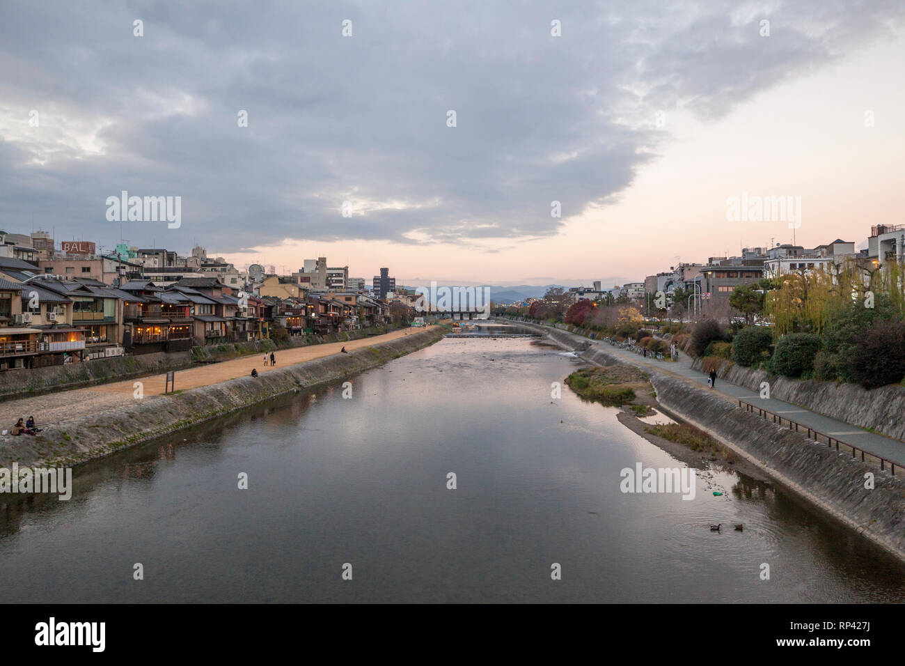 The Kamo River, in Kyoto, Japan, in winter. The riverbanks are popular ...
