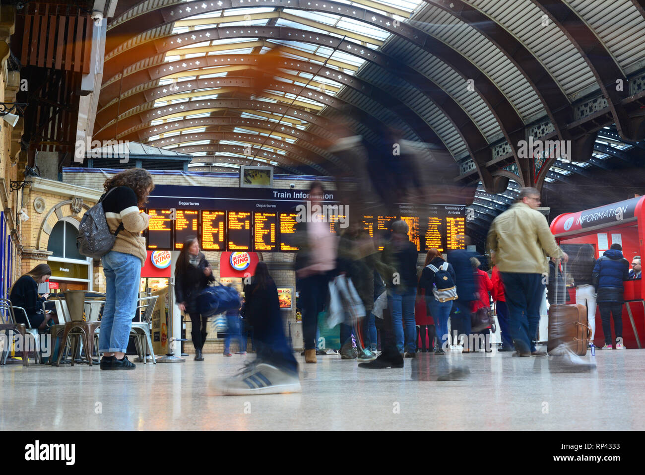 time exposure passengers looking at digital departure and arrival ...
