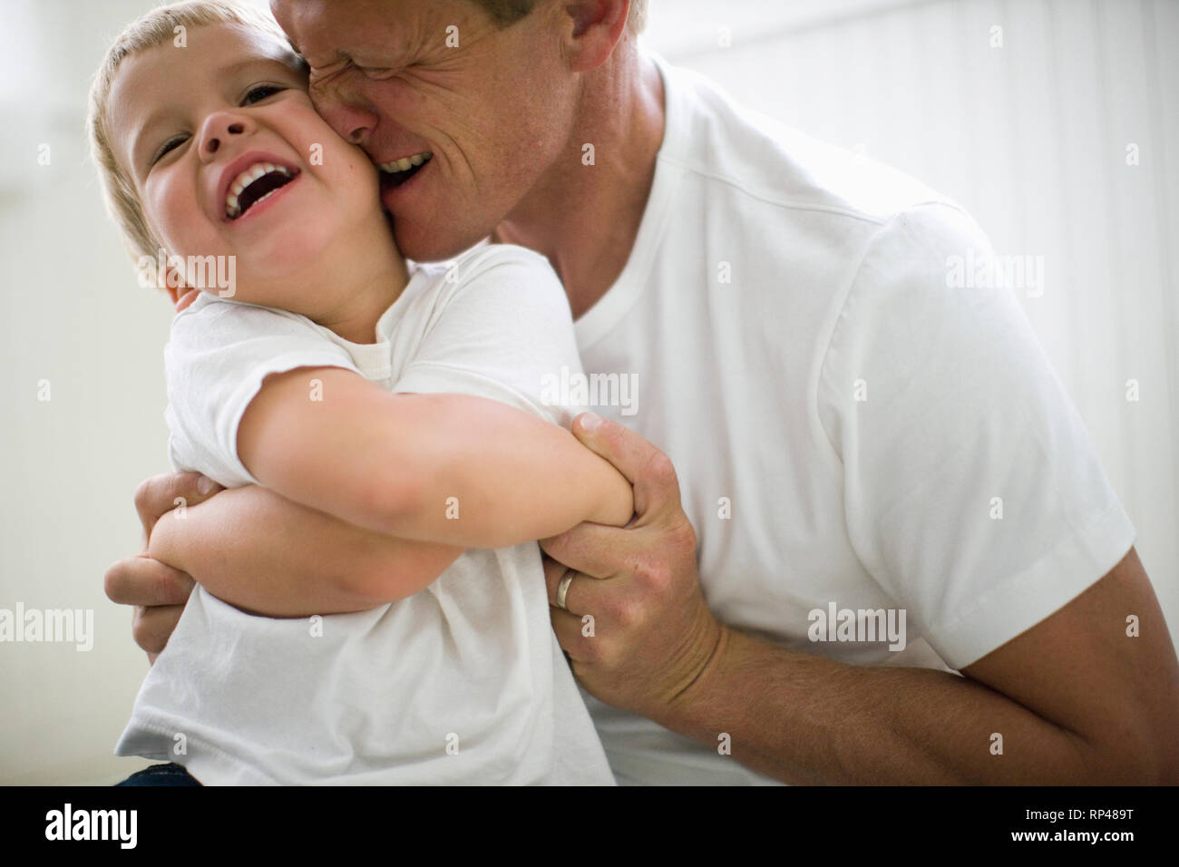 Young boy and his father hugging each other inside their house Stock ...