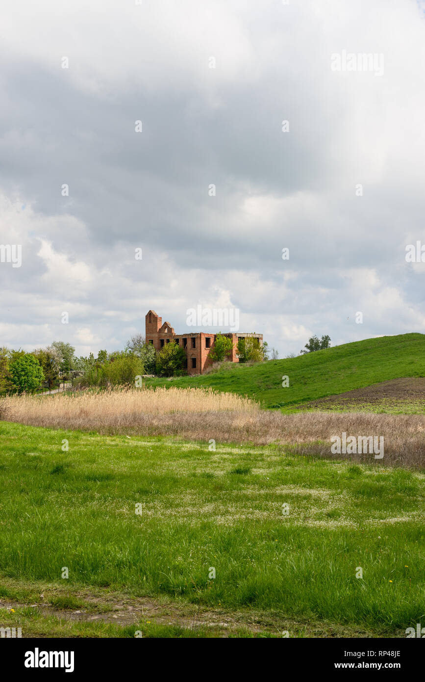 Scenic rural landscape with unfinished red brick building near green ...