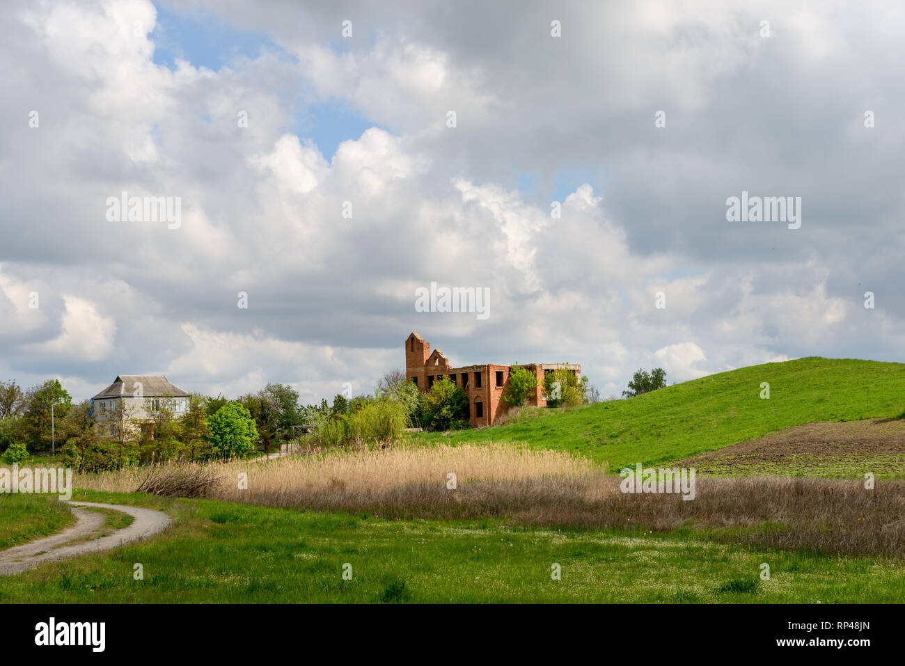 Scenic rural landscape with unfinished red brick building near green ...