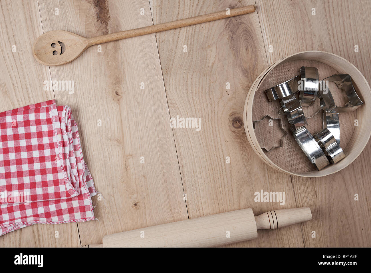 round wooden sieve with baking molds and rolling pin, top view, copy ...