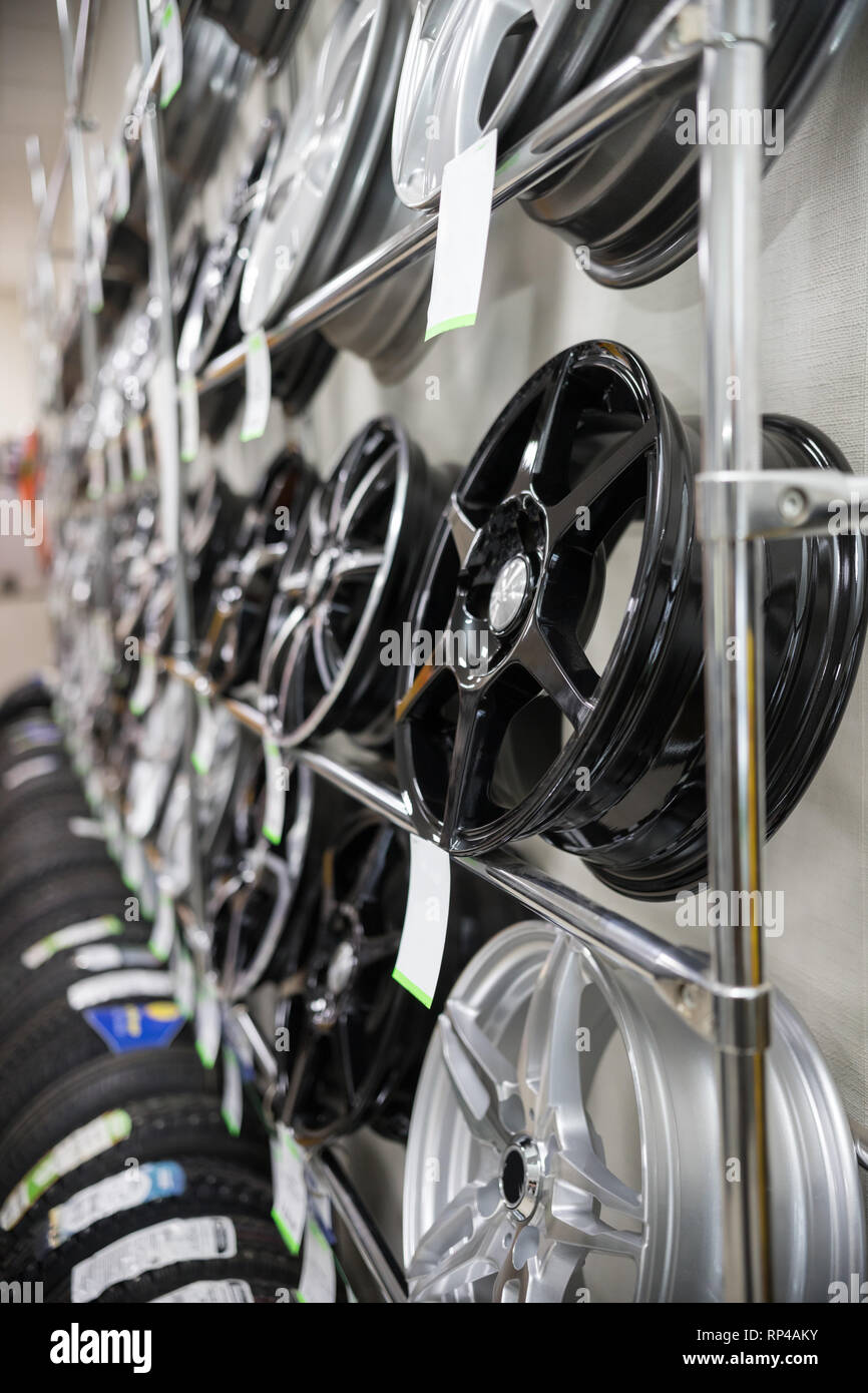 Brand new clean modern rims on the shelves in a car shop. Side view ...