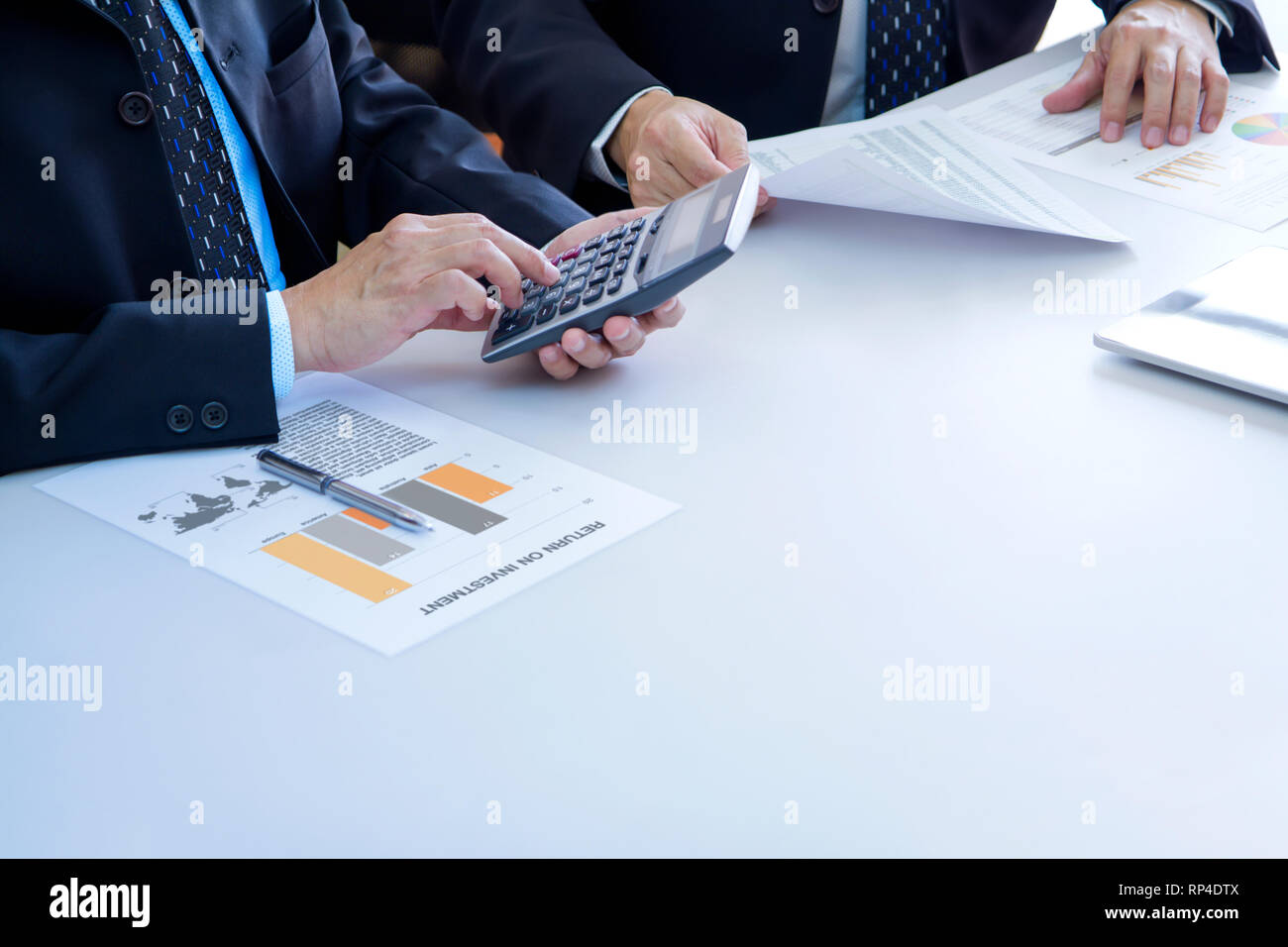 Two businessmen are deeply reviewing a financial reports for a return ...