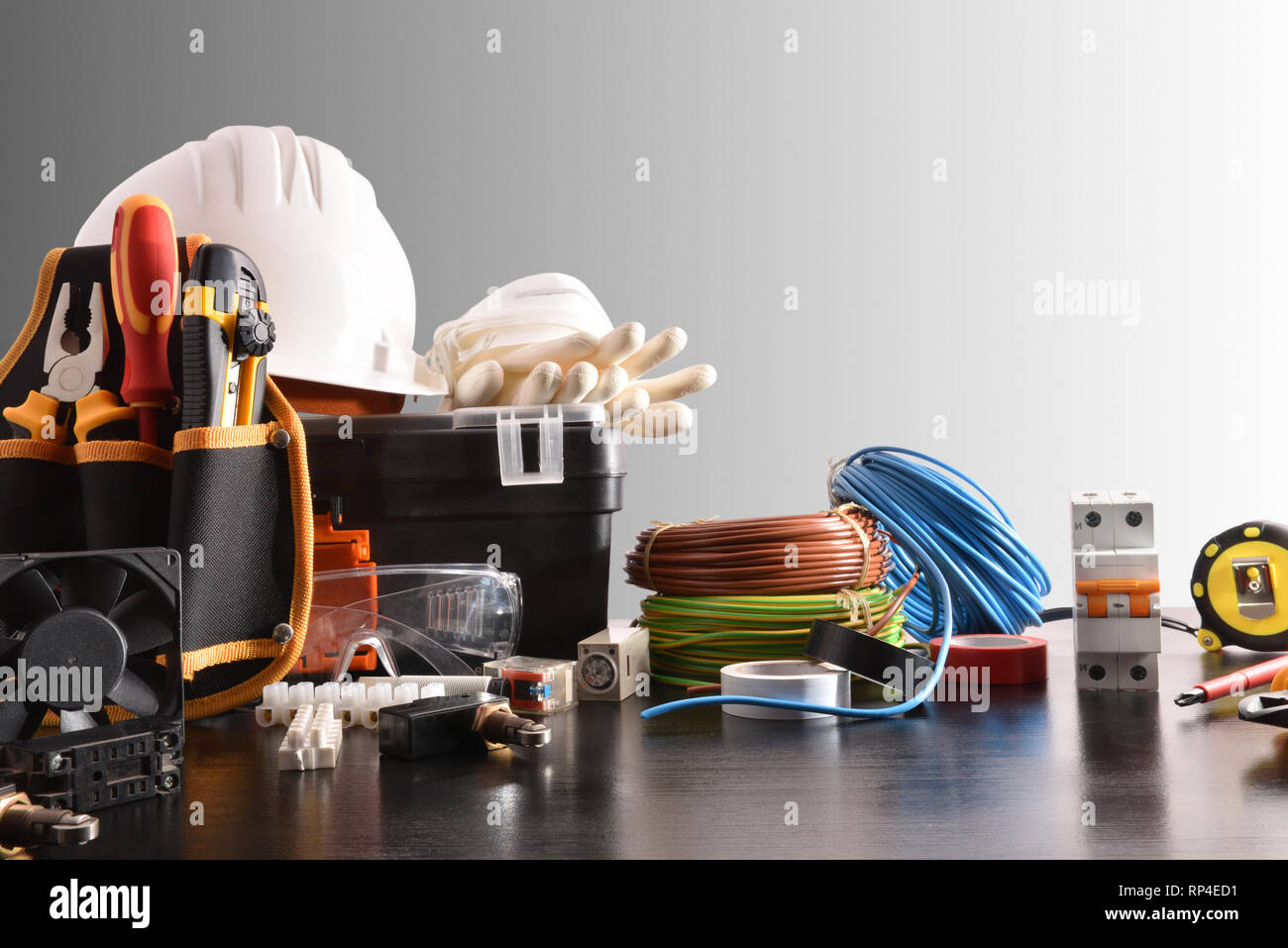 Composition with tools and electrical equipment on black table with ...