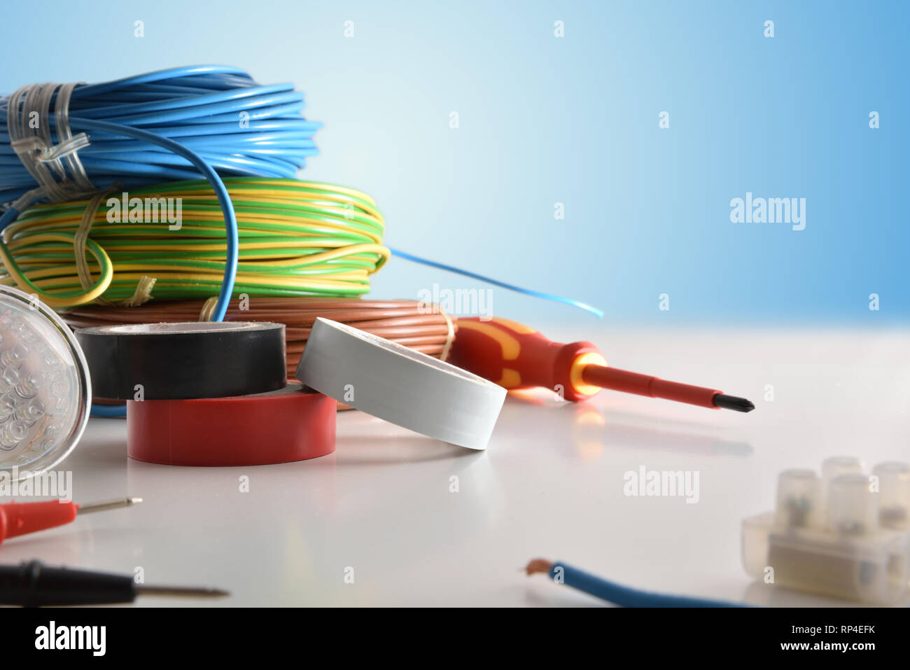 Exhibition of electrical material on wood table with blue background ...