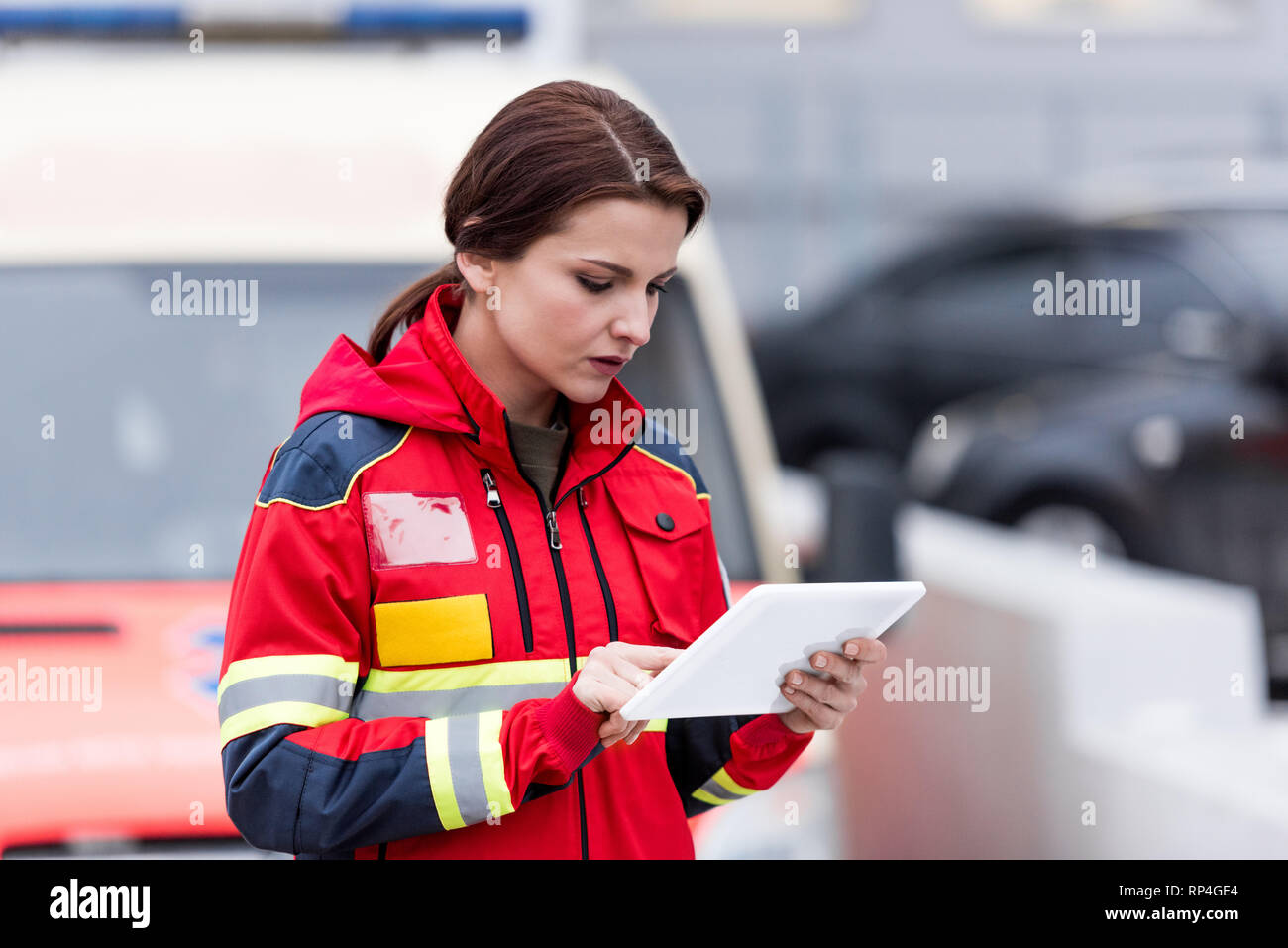 Concentrated female paramedic in uniform using digital tablet Stock ...