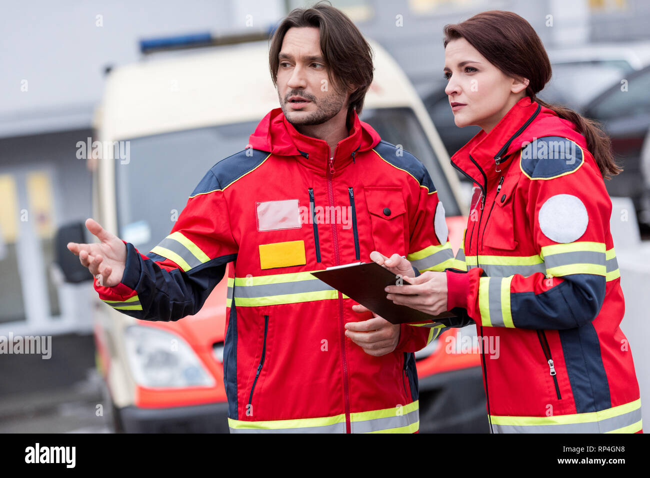 Paramedics in red uniform talking and looking away on street Stock ...