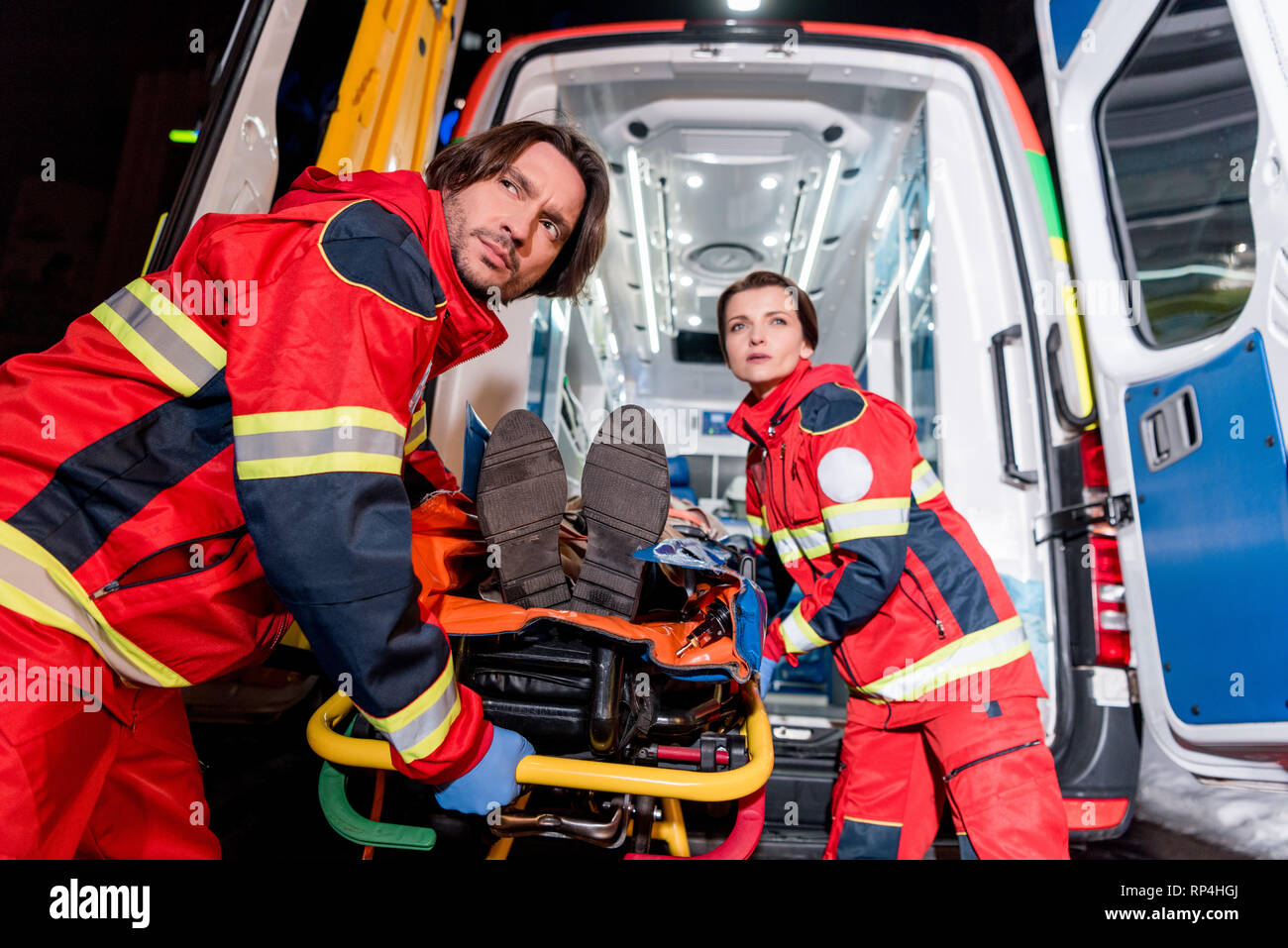 Serious paramedics transportating patient in ambulance car Stock Photo ...