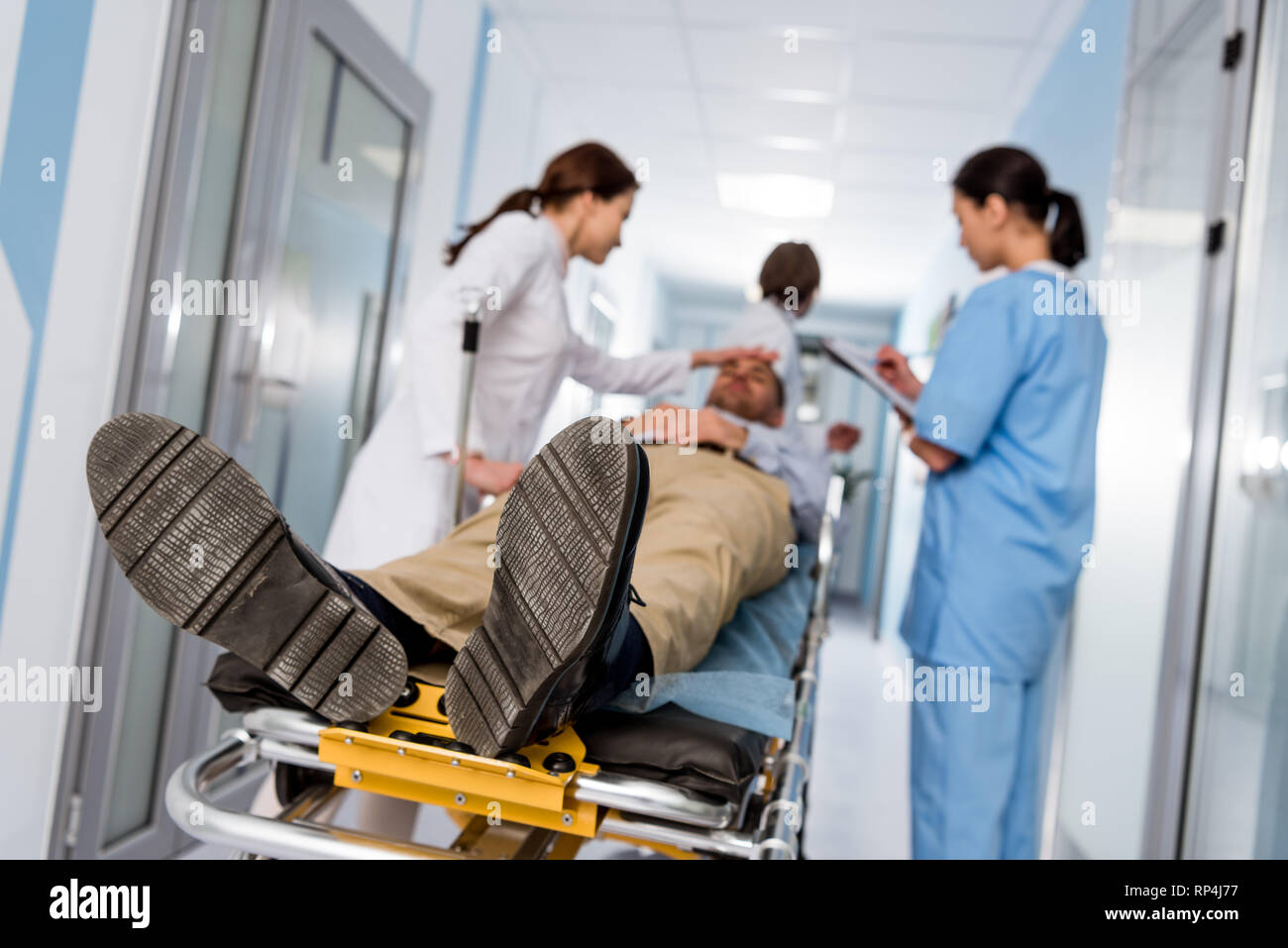 Doctors and nurse transporting patient on gurney Stock Photo - Alamy