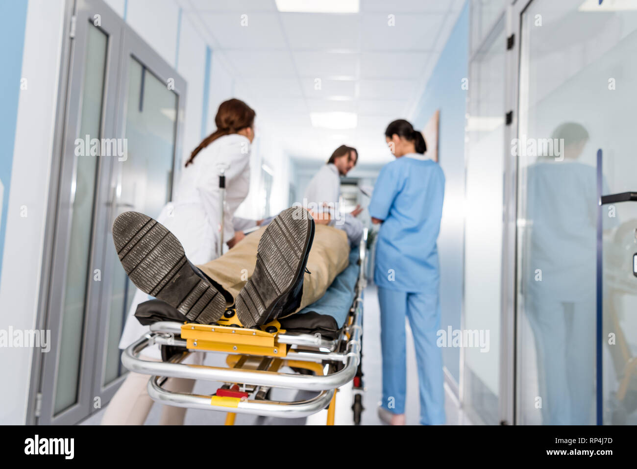 Doctors in uniform transporting patient to operating room Stock Photo ...
