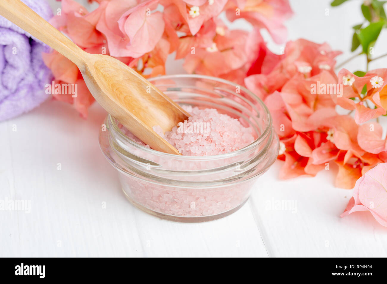Himalayan pink spa salt in a glass bowl with bougainvillea flower on a ...