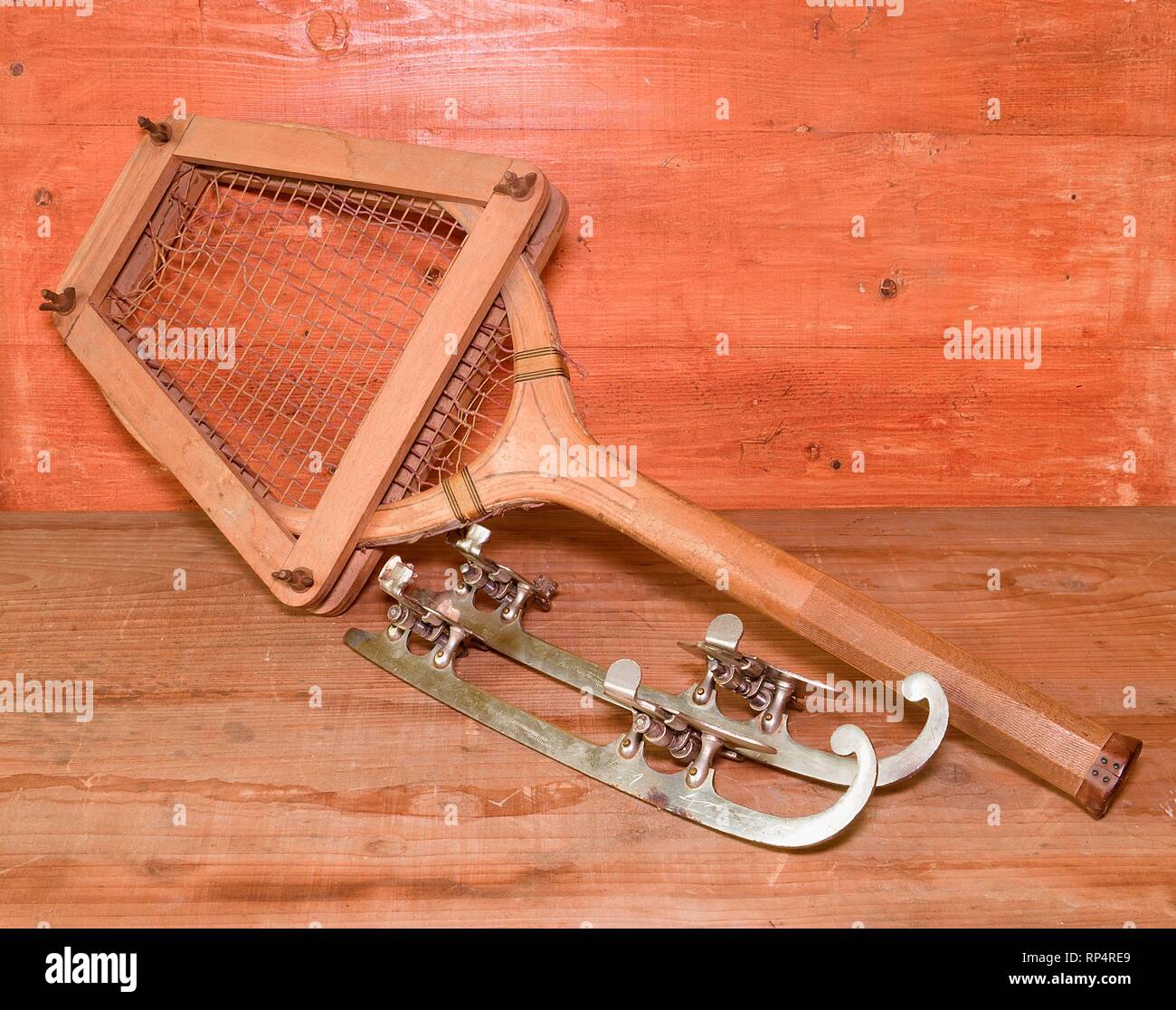 Vintage ice skates and tennis racket on wooden background. Retro ice ...