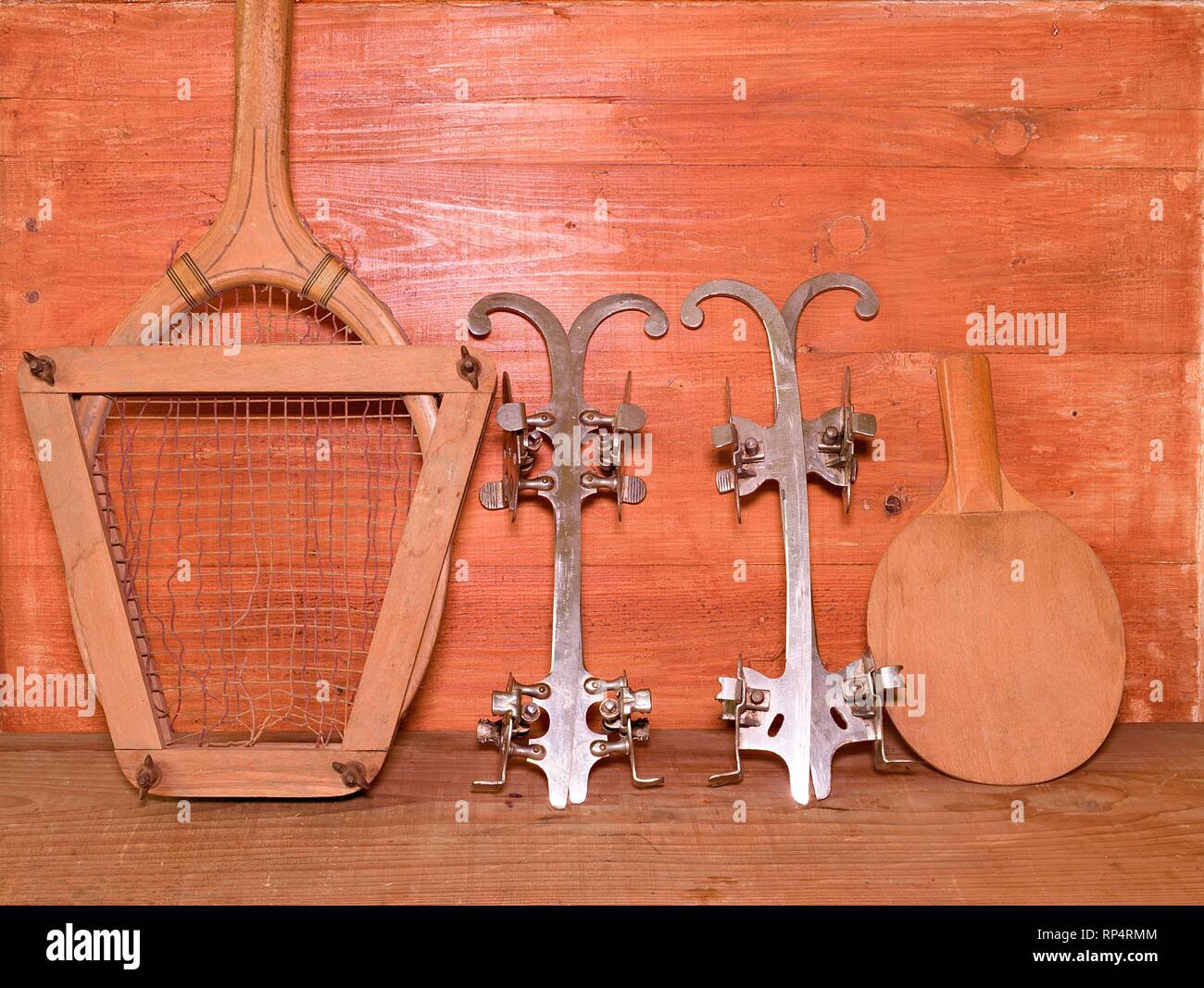 Vintage ice skates, tennis racket and table tennis racket on wooden ...