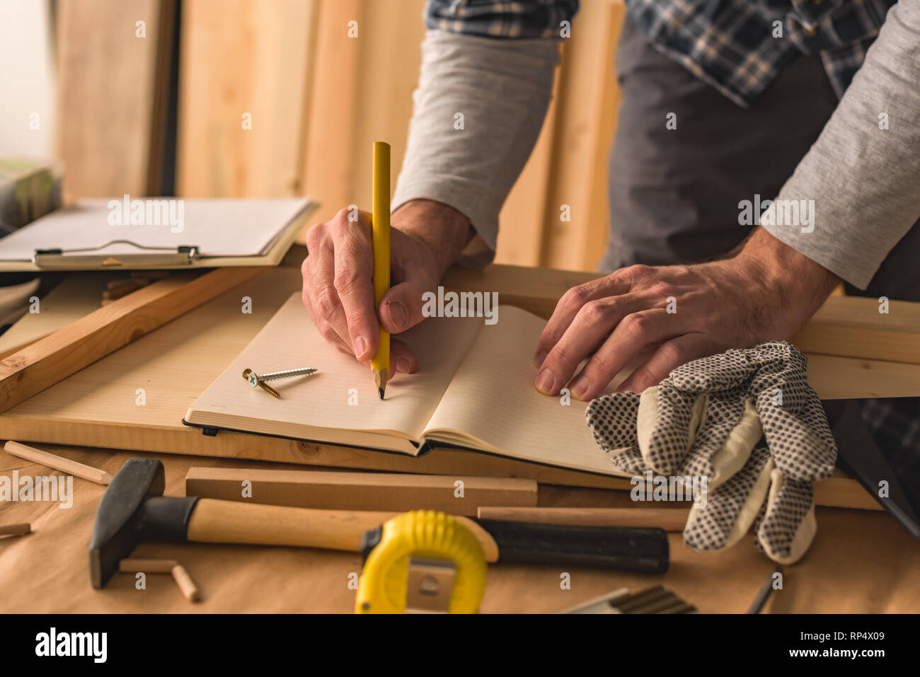 Carpenter writing project to do list in woodwork workshop Stock Photo ...