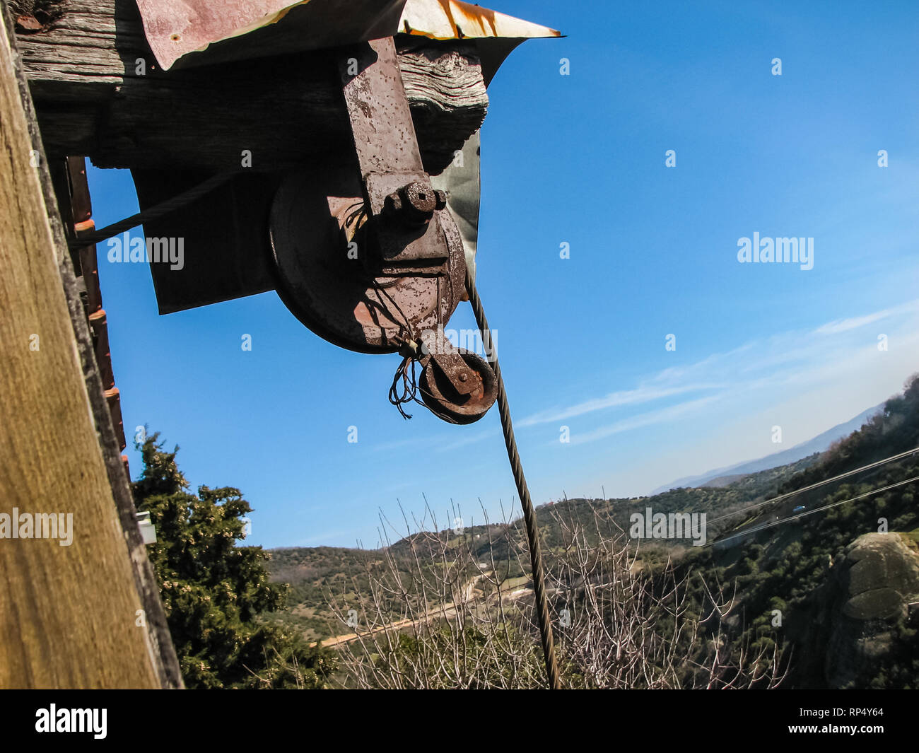 old rusty cable and suspension roller. Meteora monasteries on the rocks ...