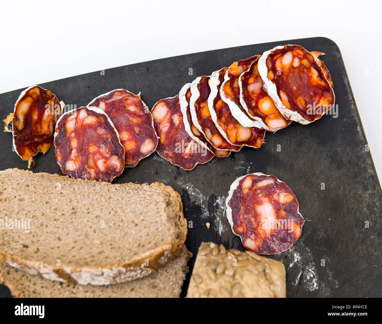 Delicious Spanish chorizo salami on black plate cut into slices with ...