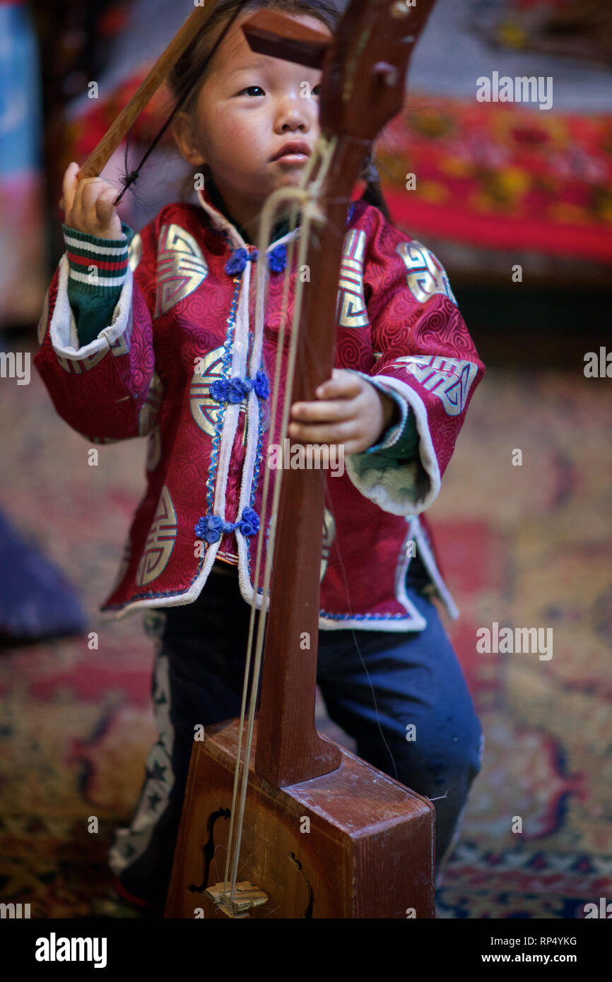 Mongolian child playing music (Morin Khuur instrument), Gobi desert ...