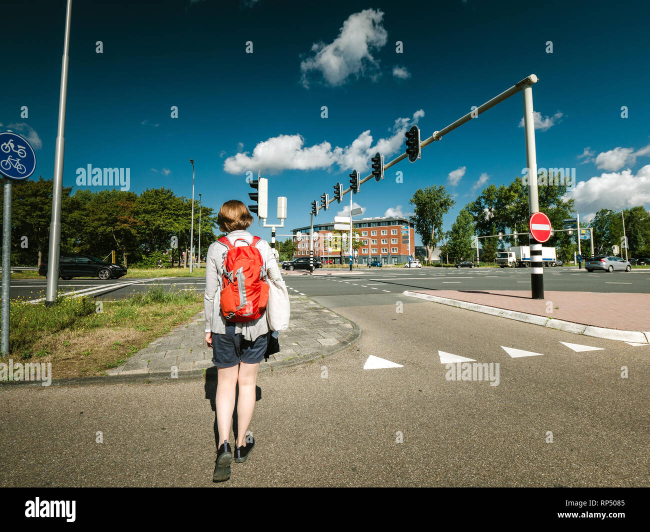Rear view of young woman walking on a intersection in central Haarlem ...