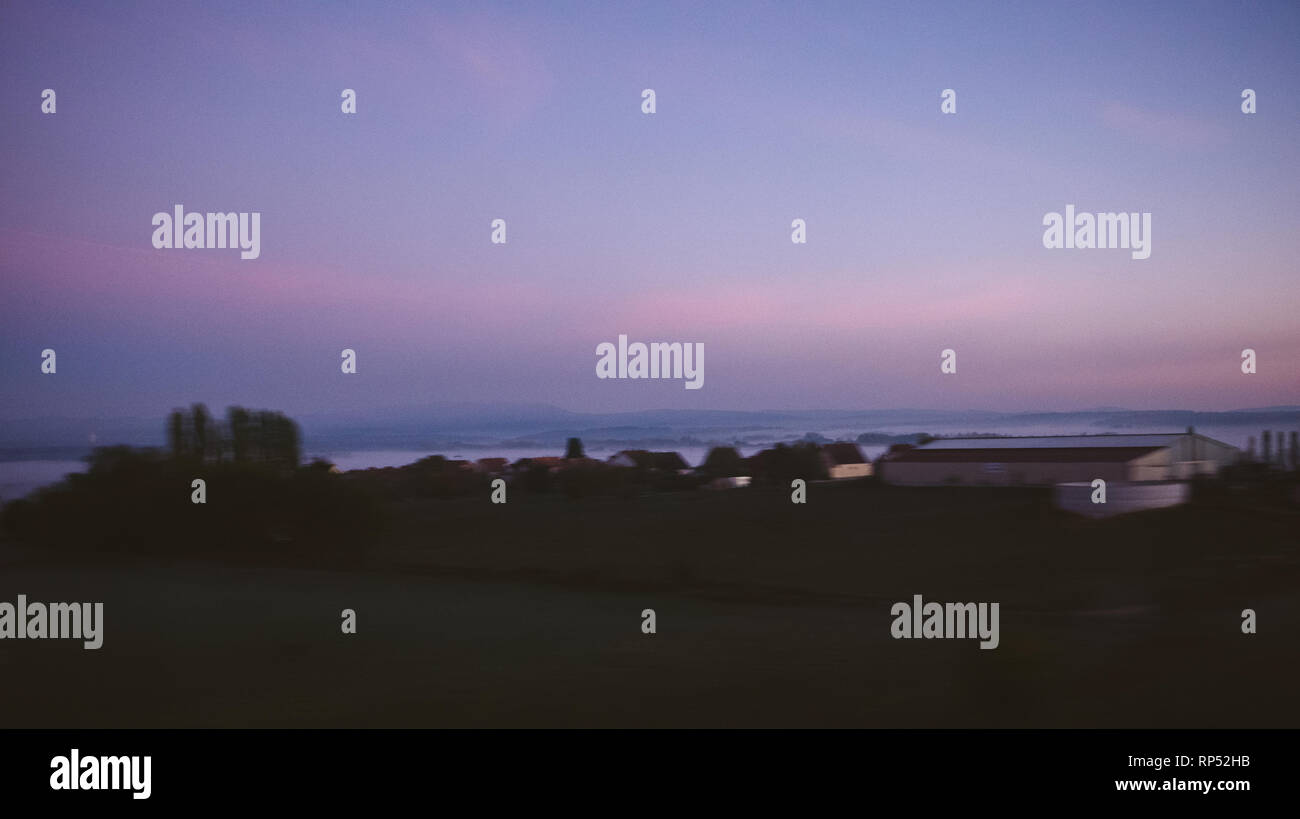 Cinematic purple color sky with mist over French hills and cities view ...