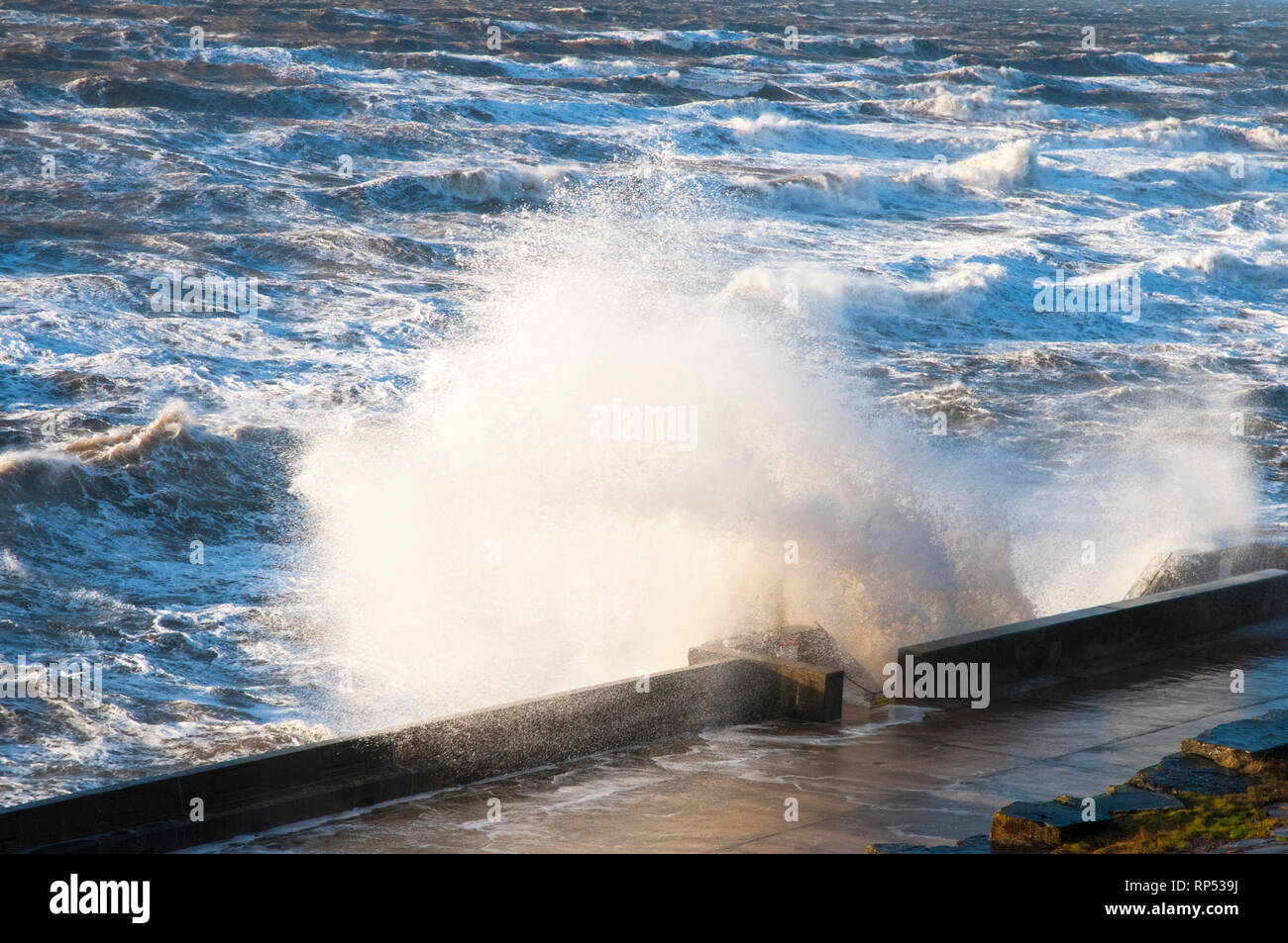Waves crashing against the seawall in strong winds on north shore ...