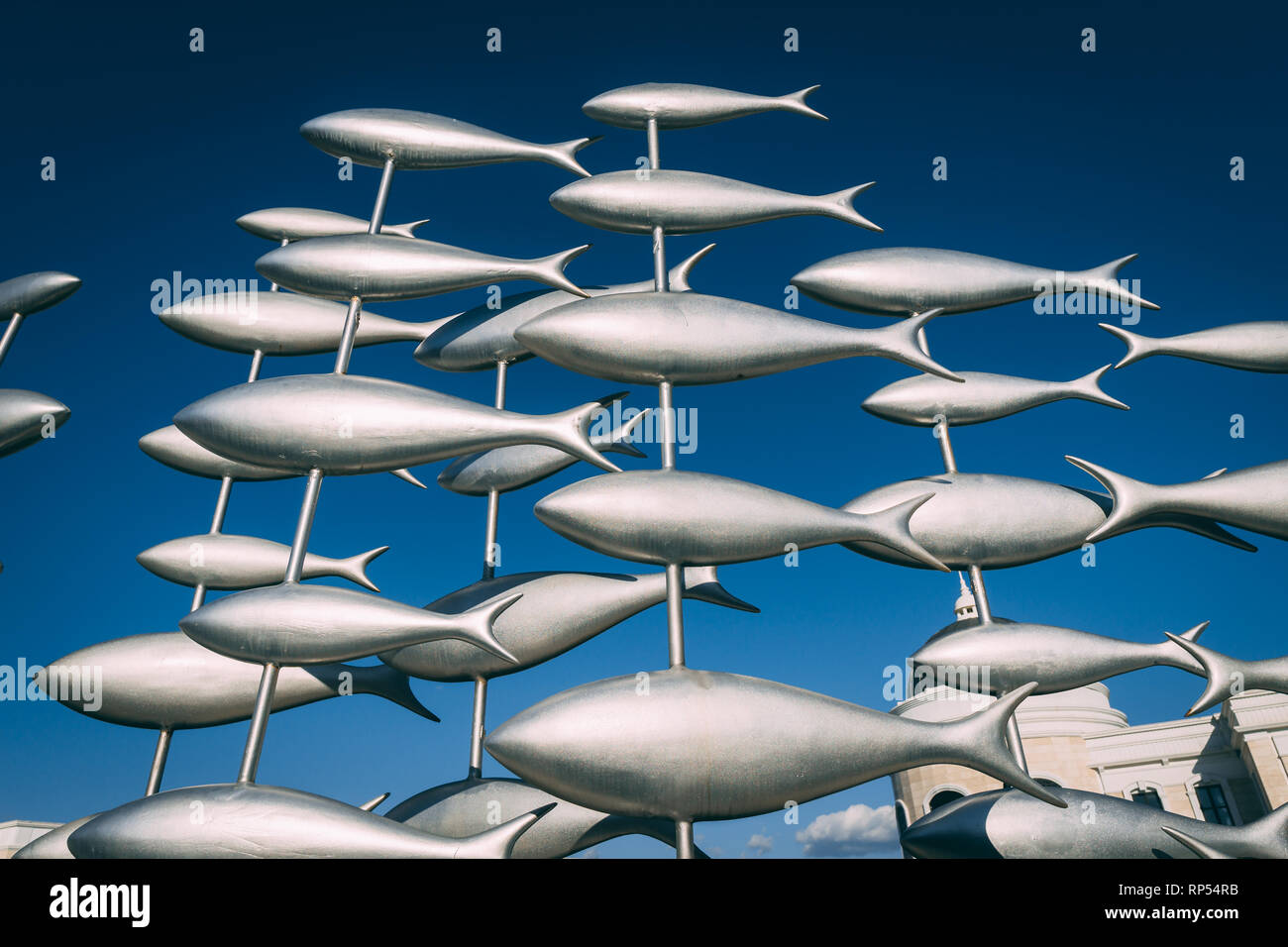 Statue of silver fish figures on poles. Metalic statue of many fishes ...