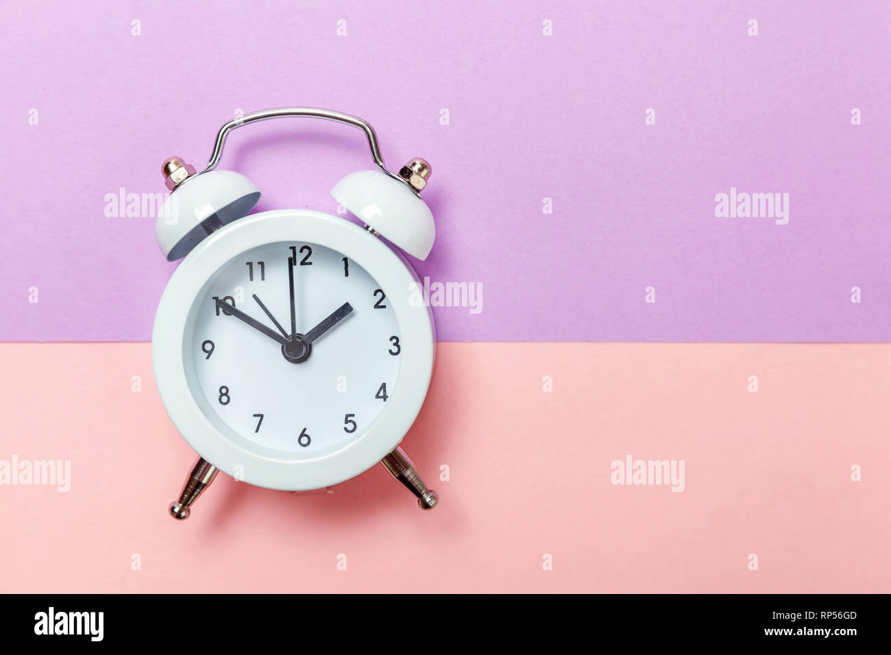 Ringing twin bell vintage classic alarm clock Isolated on purple pink ...