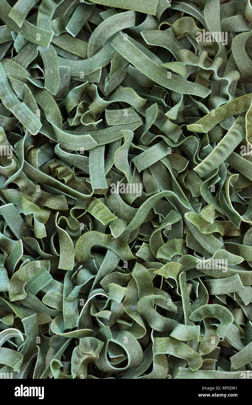 Sprouted spelt spirulina organic tagliatelle pasta forming an abstract ...