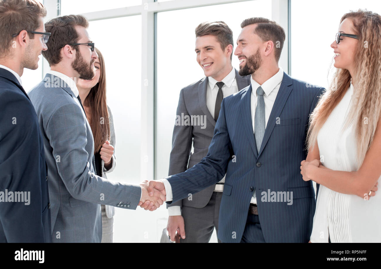 employees greet each other with a handshake Stock Photo - Alamy
