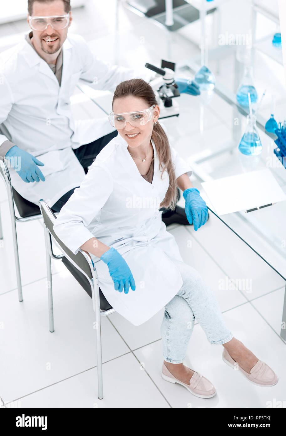two positive scientists work sitting at a laboratory table Stock Photo ...