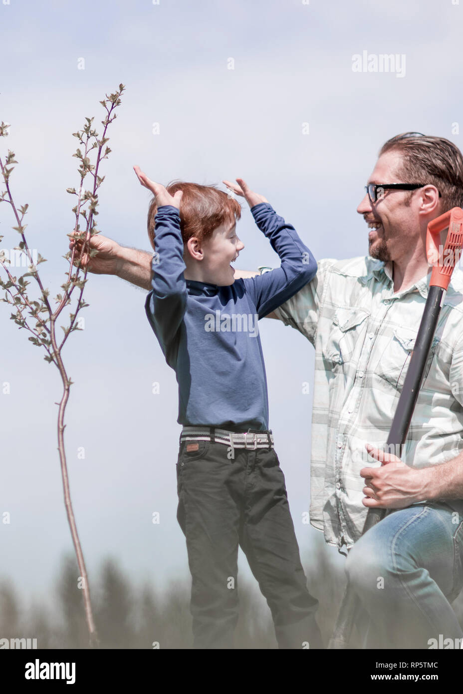 happy father and son plant a young tree Stock Photo - Alamy