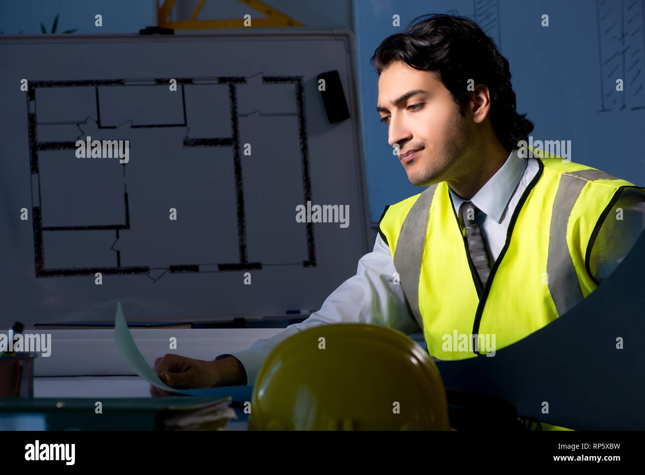 Young construction architect working on project at night Stock Photo ...