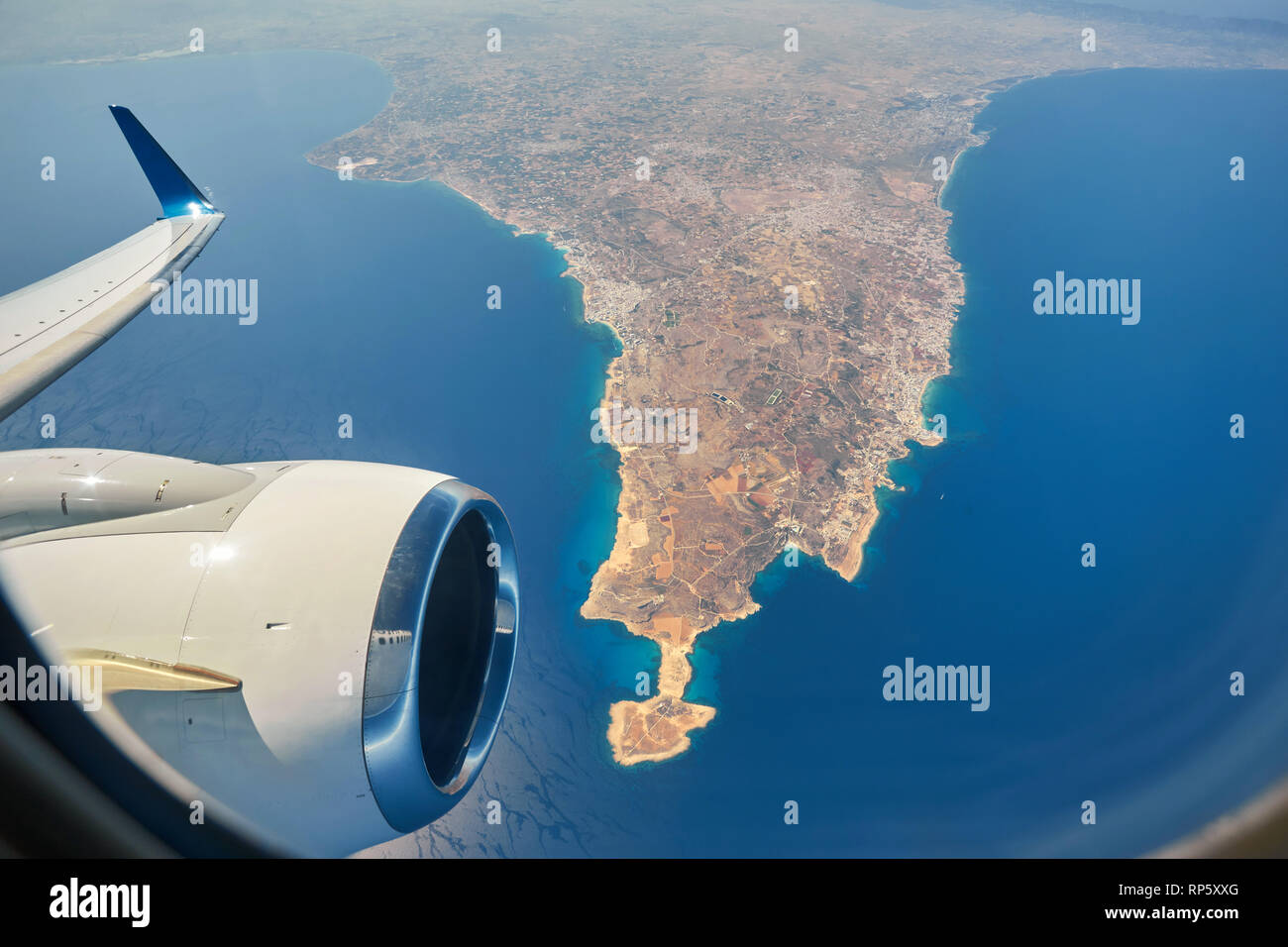 The plane is flying over the island of Cyprus. Airplane wing in flight ...