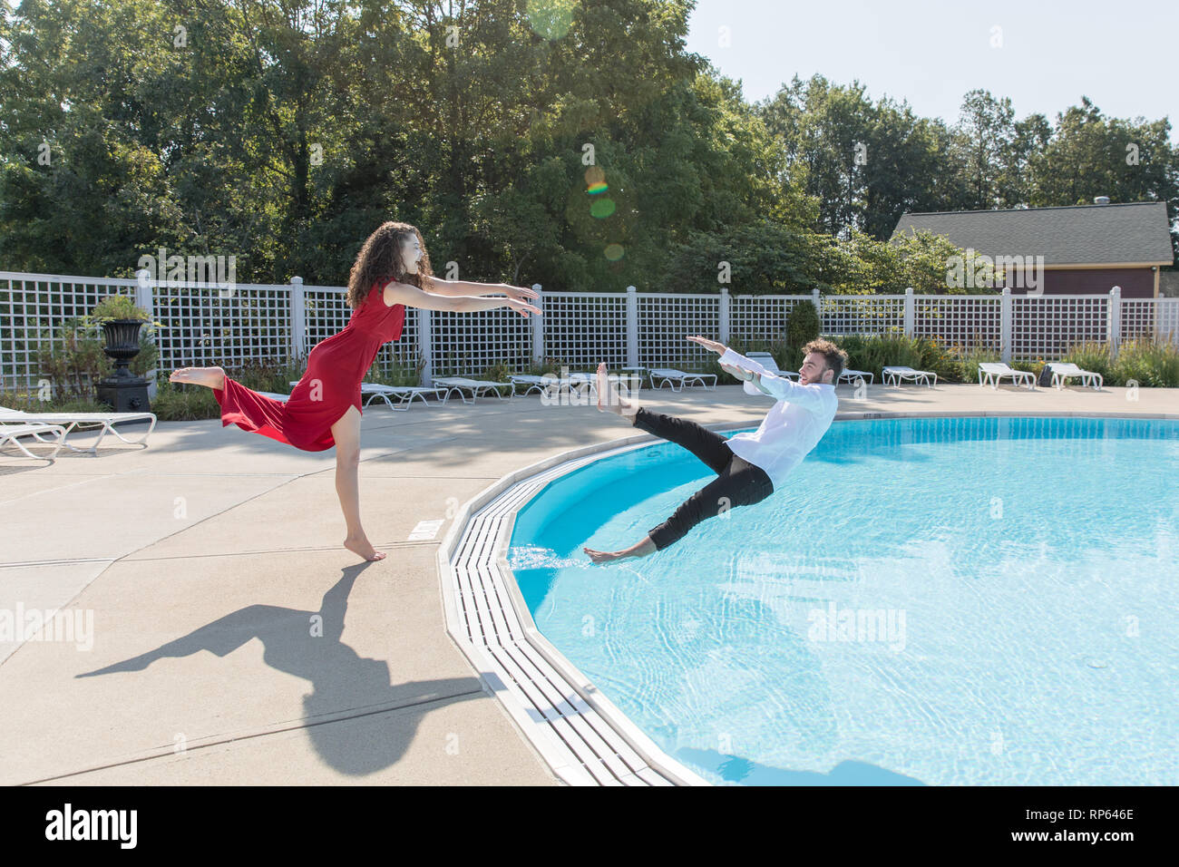 A young couple goofing around by a pool Stock Photo - Alamy