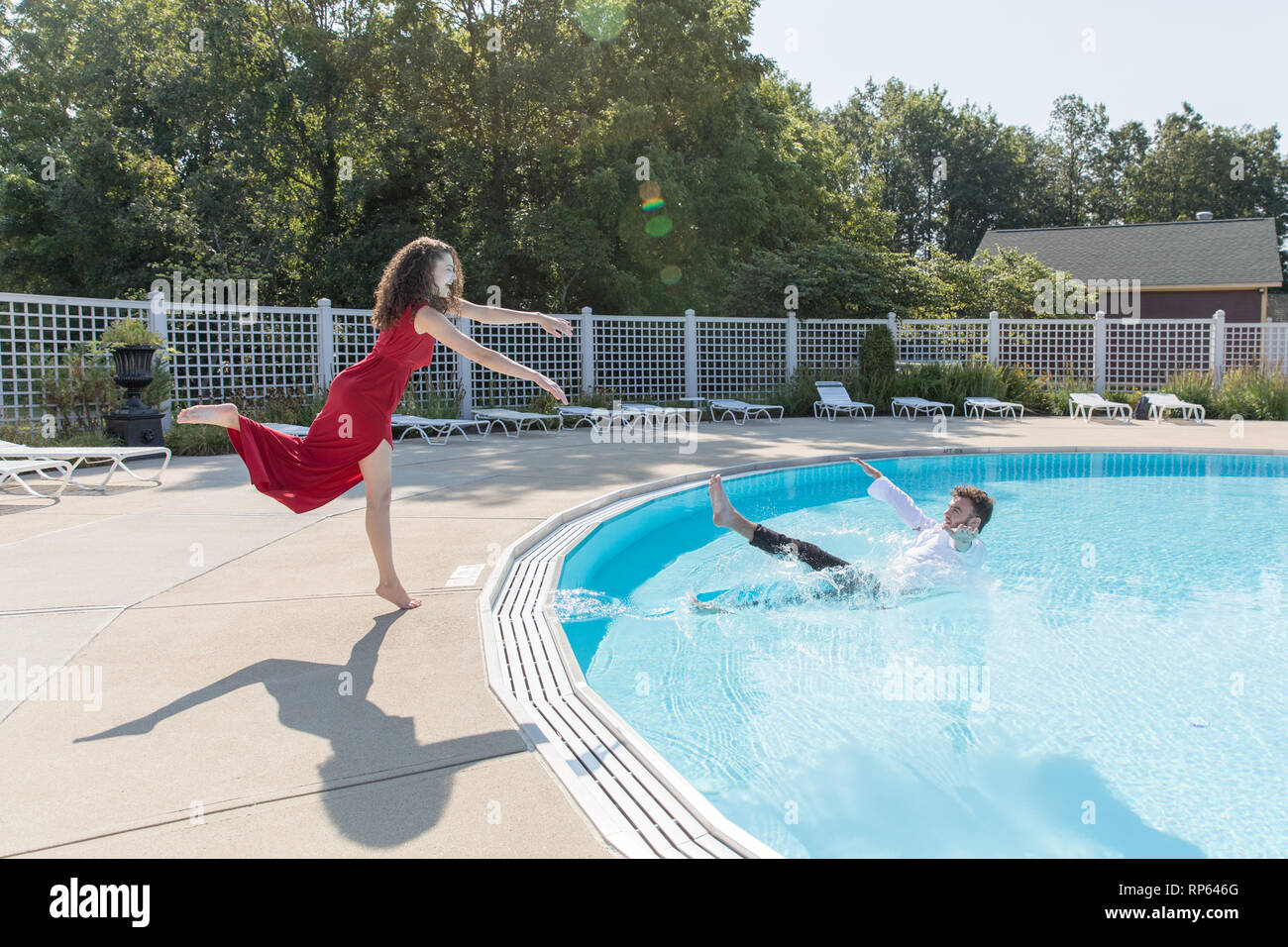 A young couple goofing around by a pool Stock Photo - Alamy