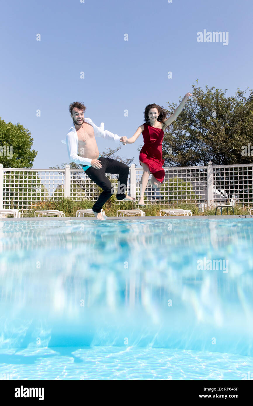 A young couple goofing around by a pool Stock Photo - Alamy