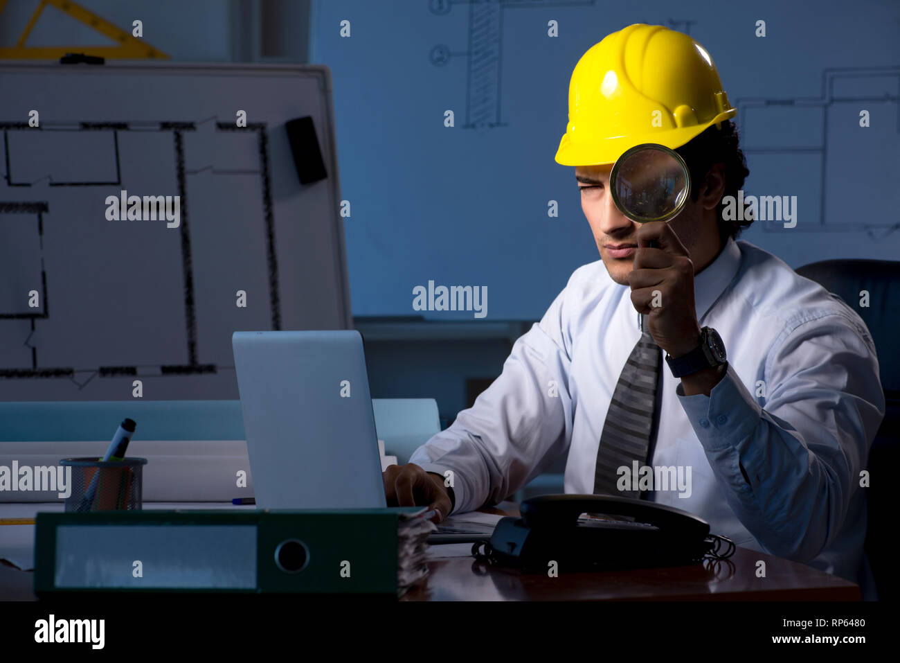 Young construction architect working on project at night Stock Photo ...