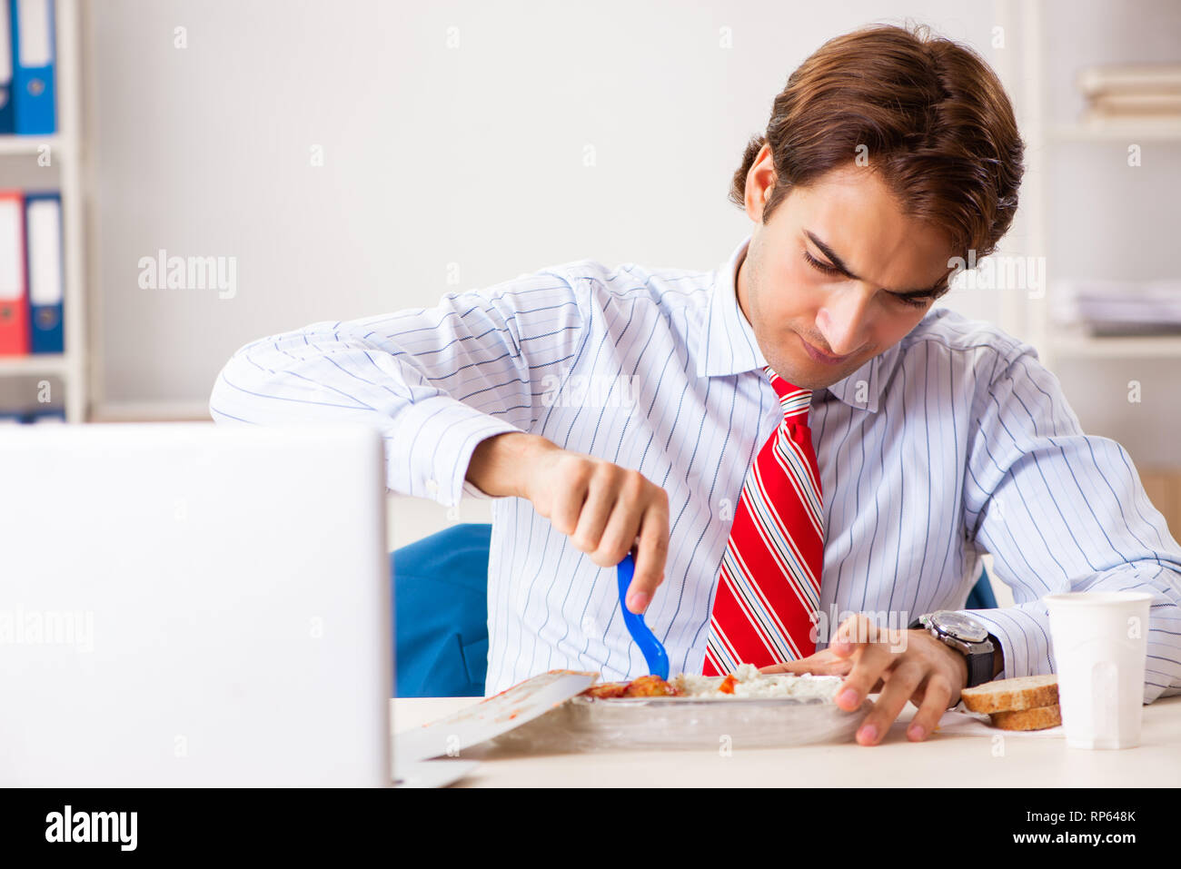 Man having meal at work during break Stock Photo - Alamy