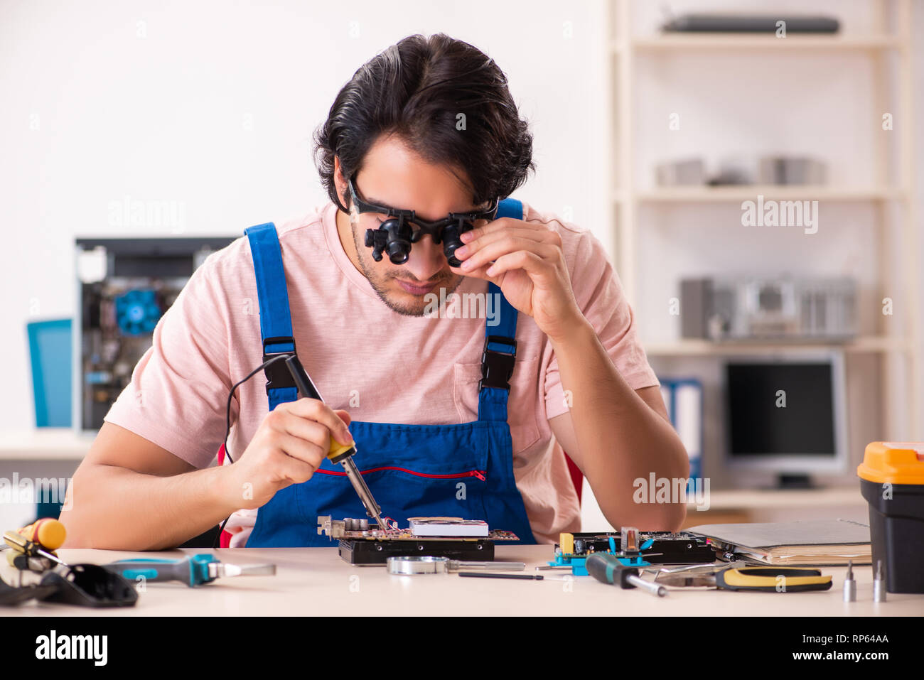 Young male contractor repairing computer Stock Photo - Alamy